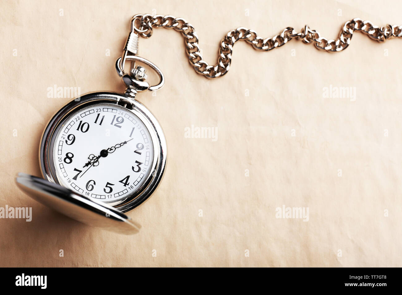 Silver pocket clock on old paper background Stock Photo - Alamy