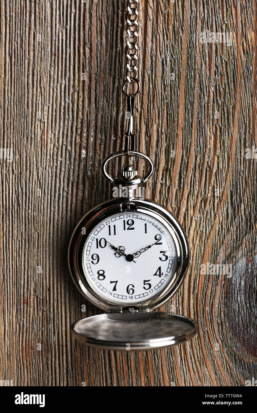 Silver pocket clock on wooden background Stock Photo - Alamy