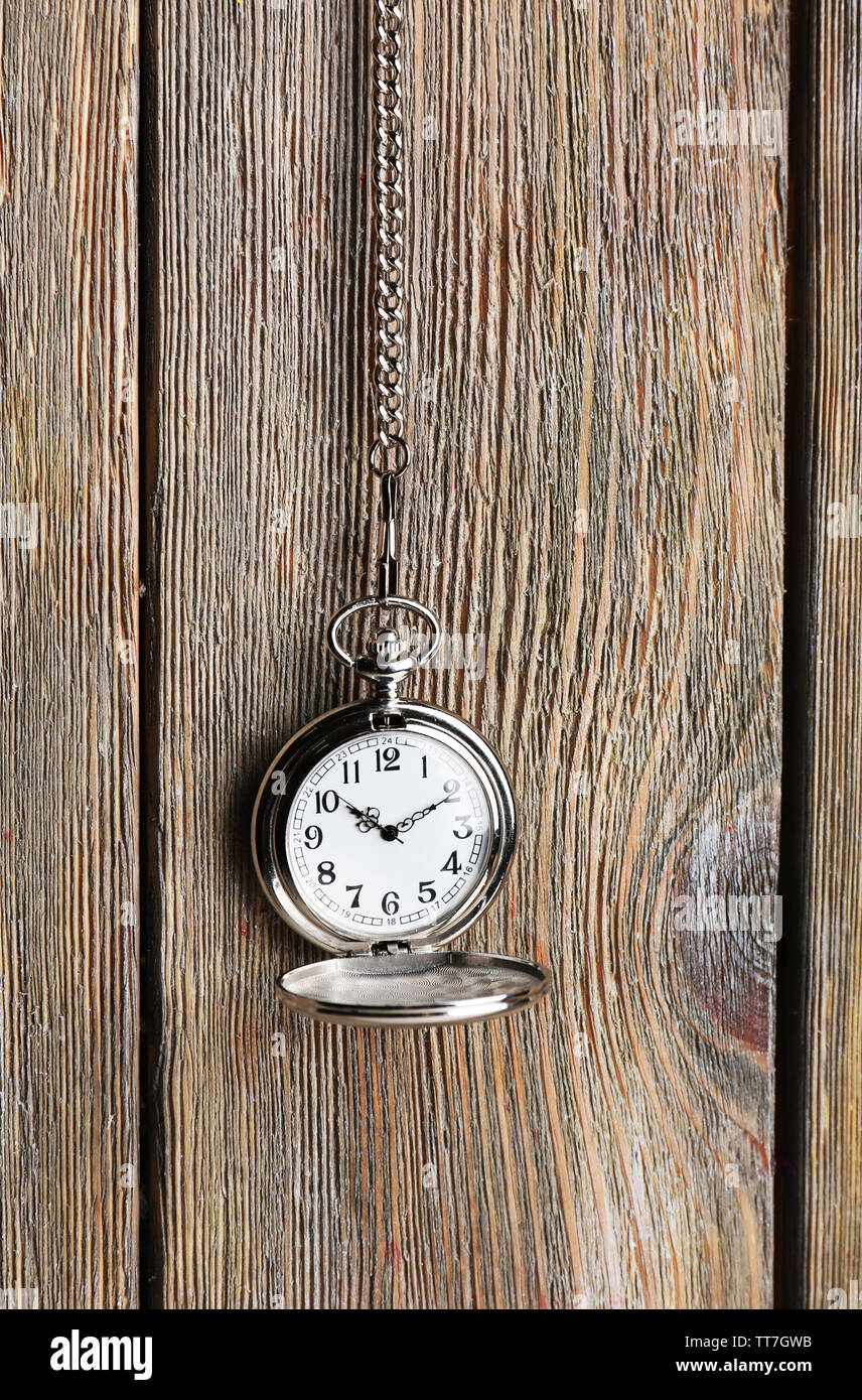 Silver pocket clock on wooden background Stock Photo - Alamy