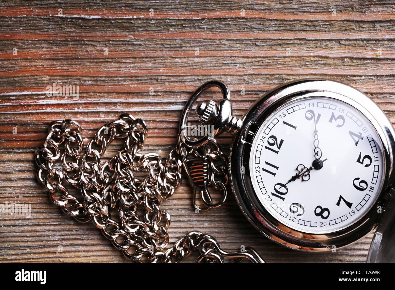 Silver pocket clock on wooden table Stock Photo - Alamy