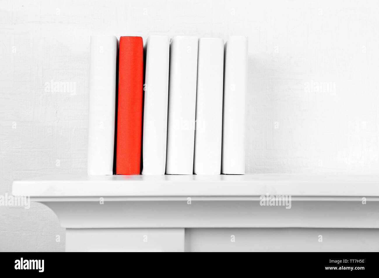 Books on shelf on wall background Stock Photo - Alamy