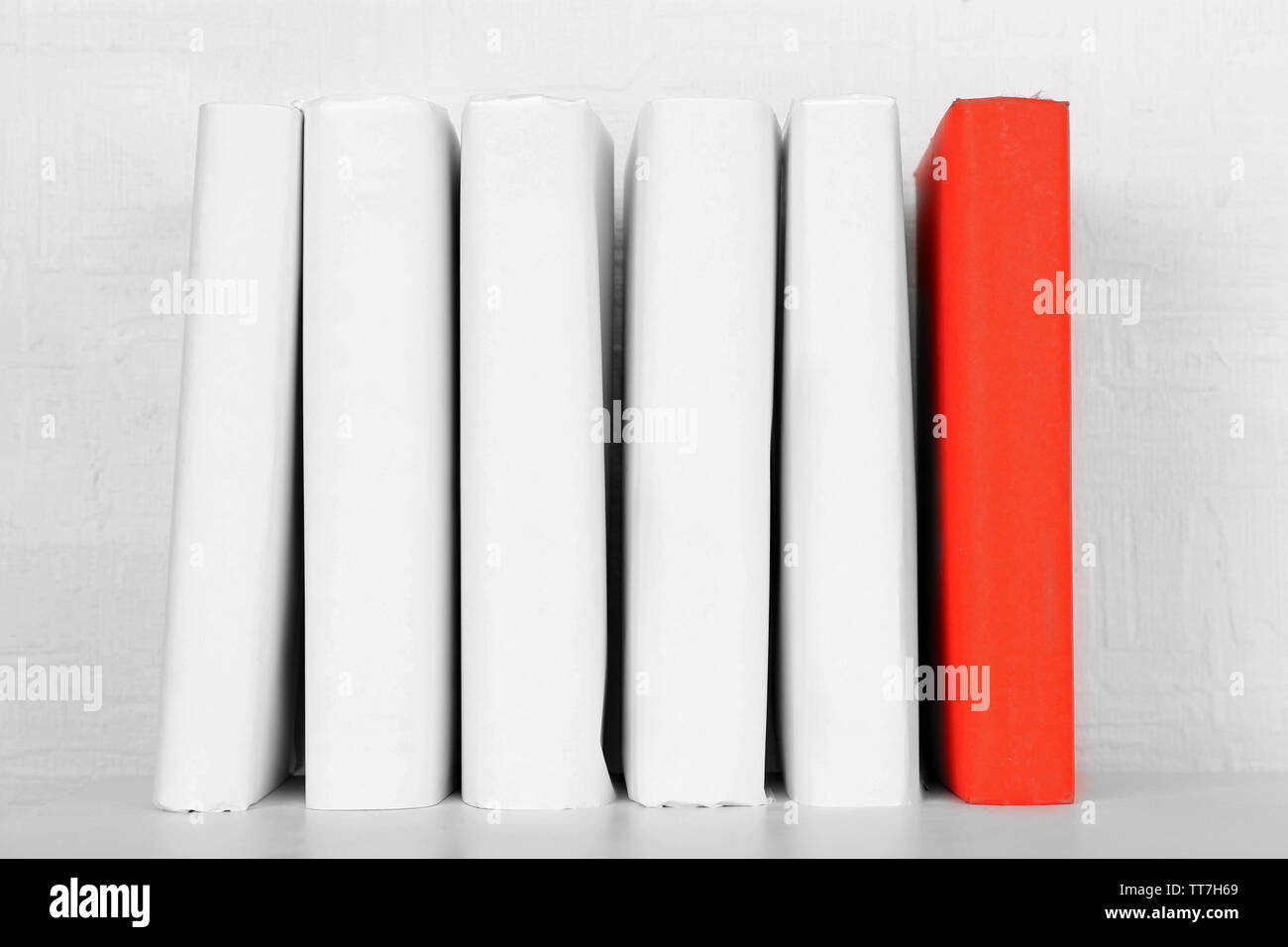 Books on shelf on wall background Stock Photo - Alamy