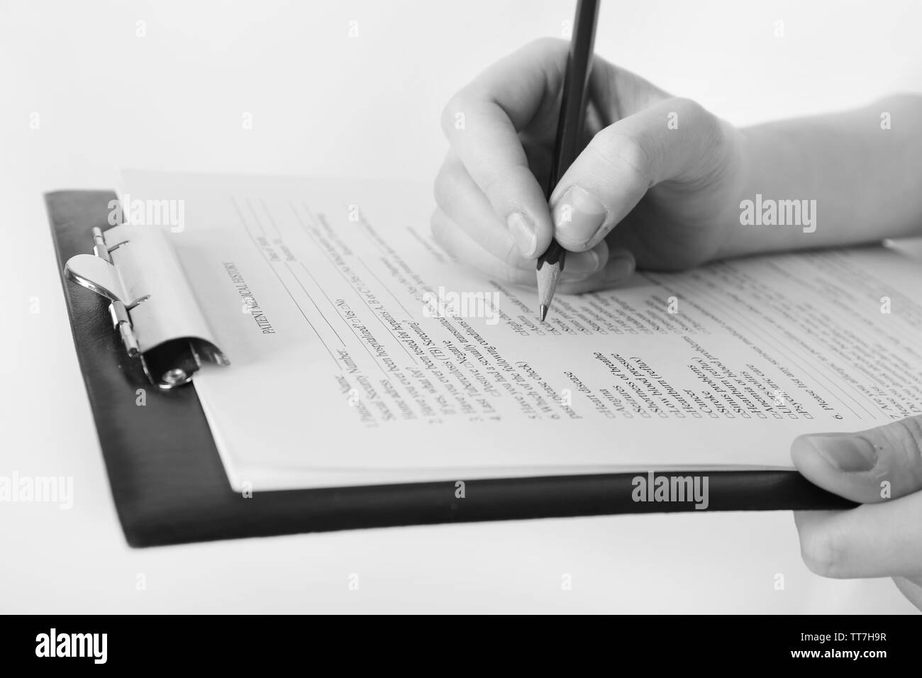 Woman filling medical history on light background Stock Photo - Alamy