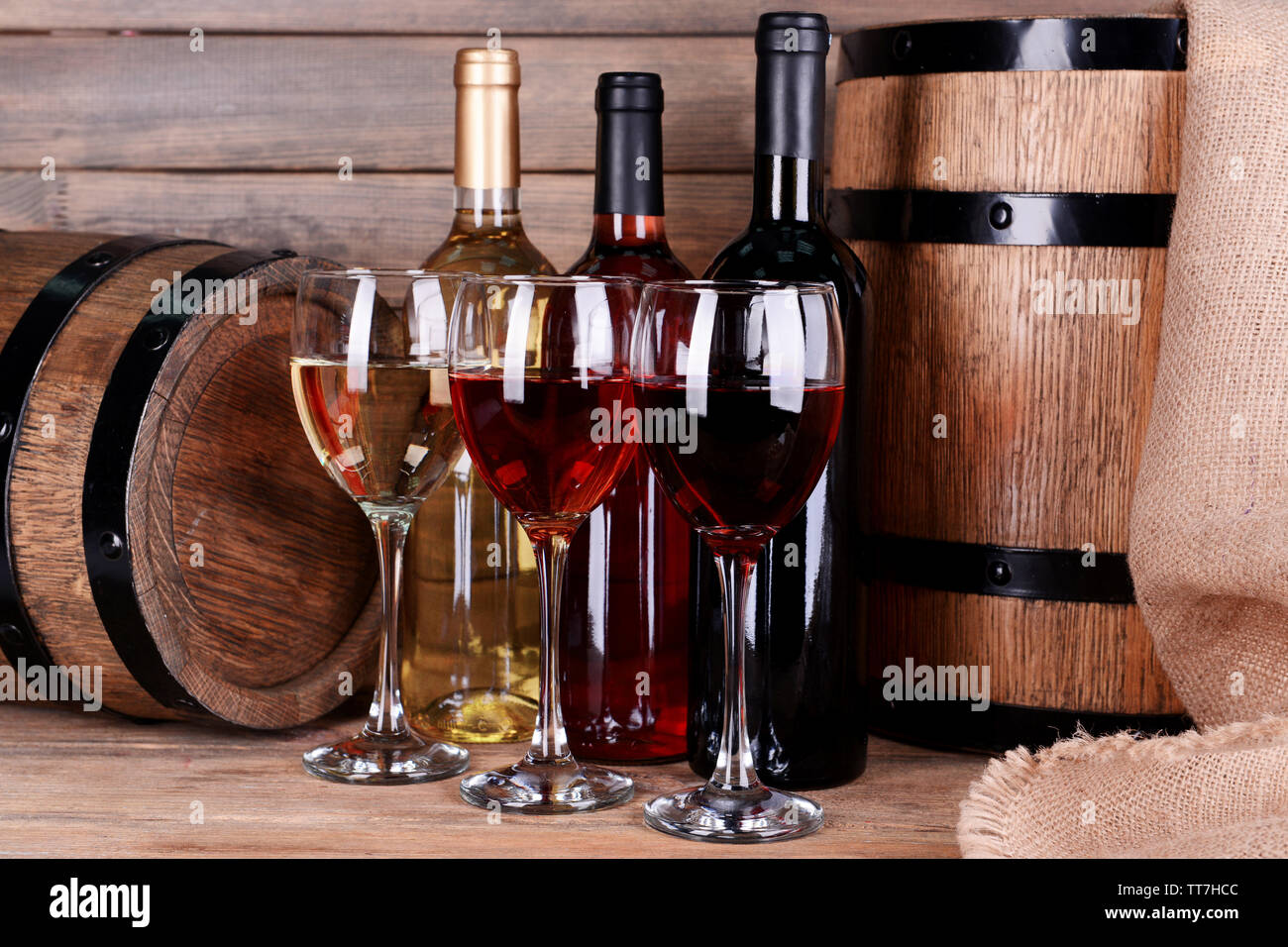 Different wine on table on wooden background Stock Photo - Alamy