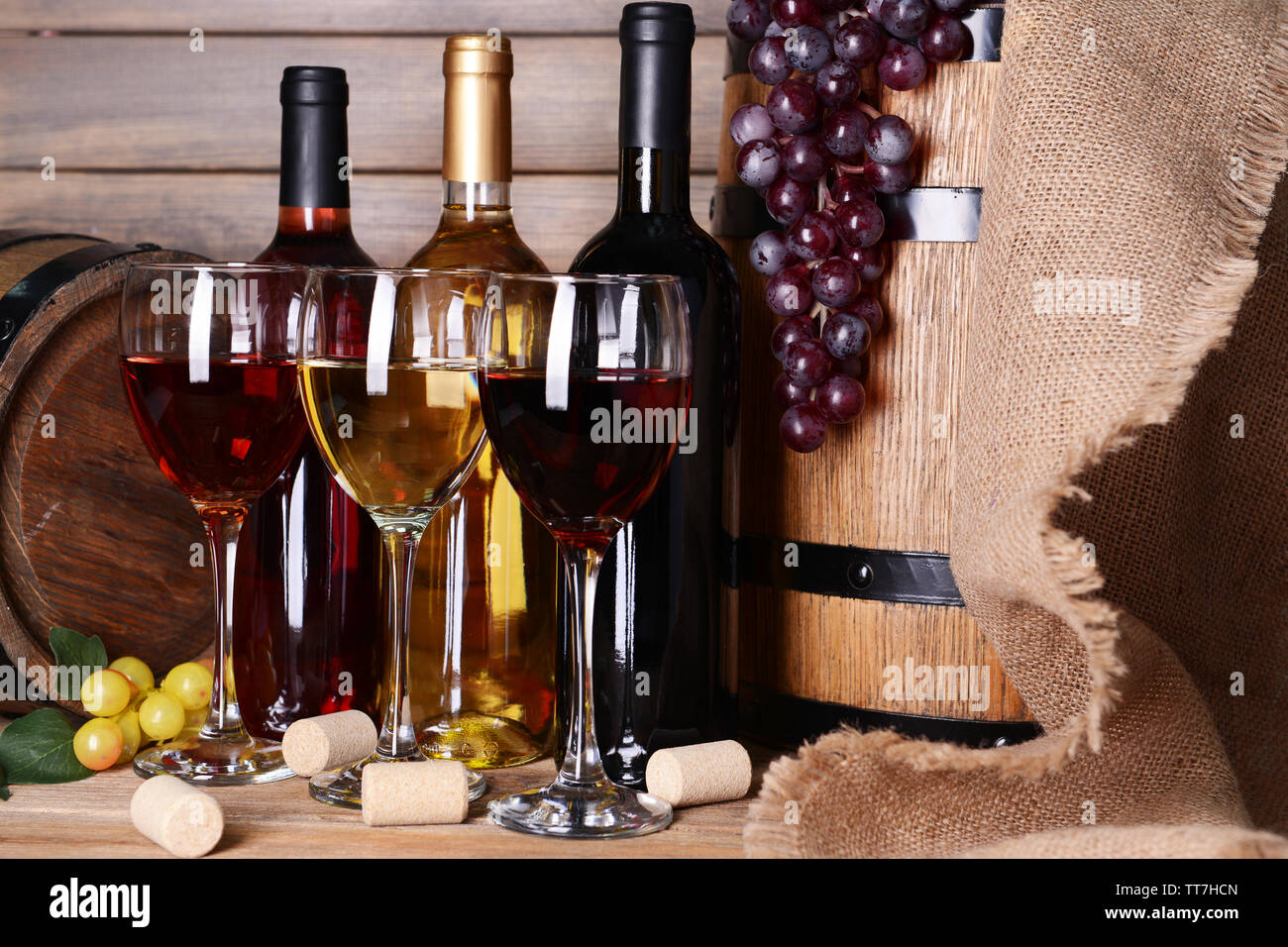 Different wine on table on wooden background Stock Photo - Alamy