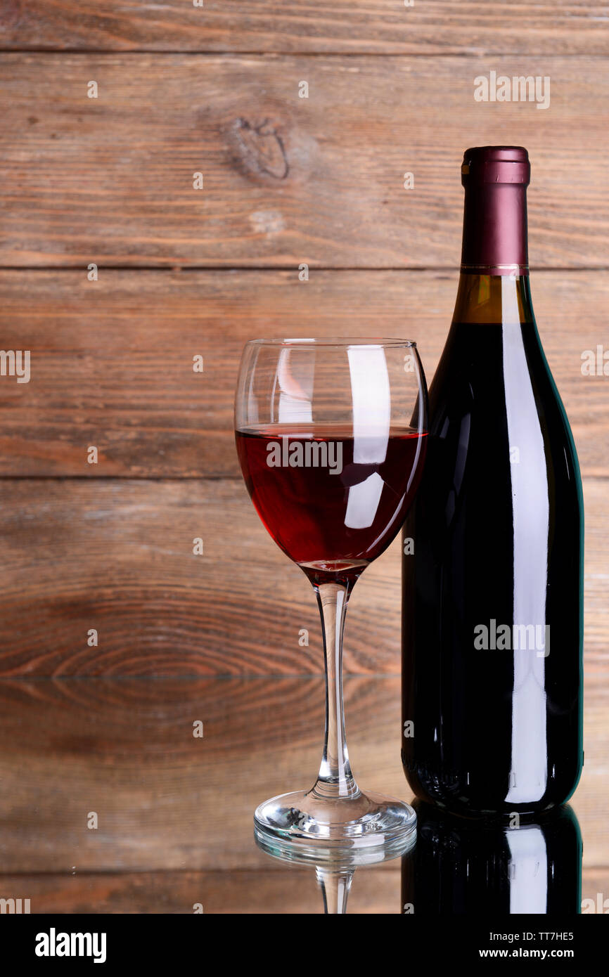 Red wine on table on wooden background Stock Photo - Alamy