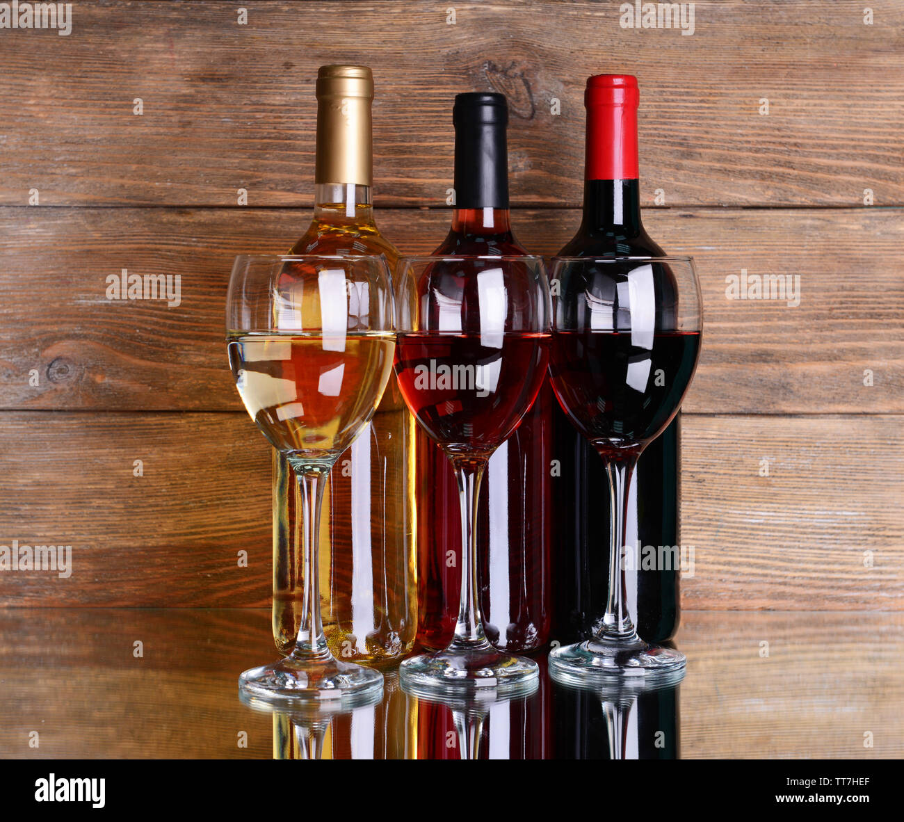 Different wine on table on wooden background Stock Photo - Alamy