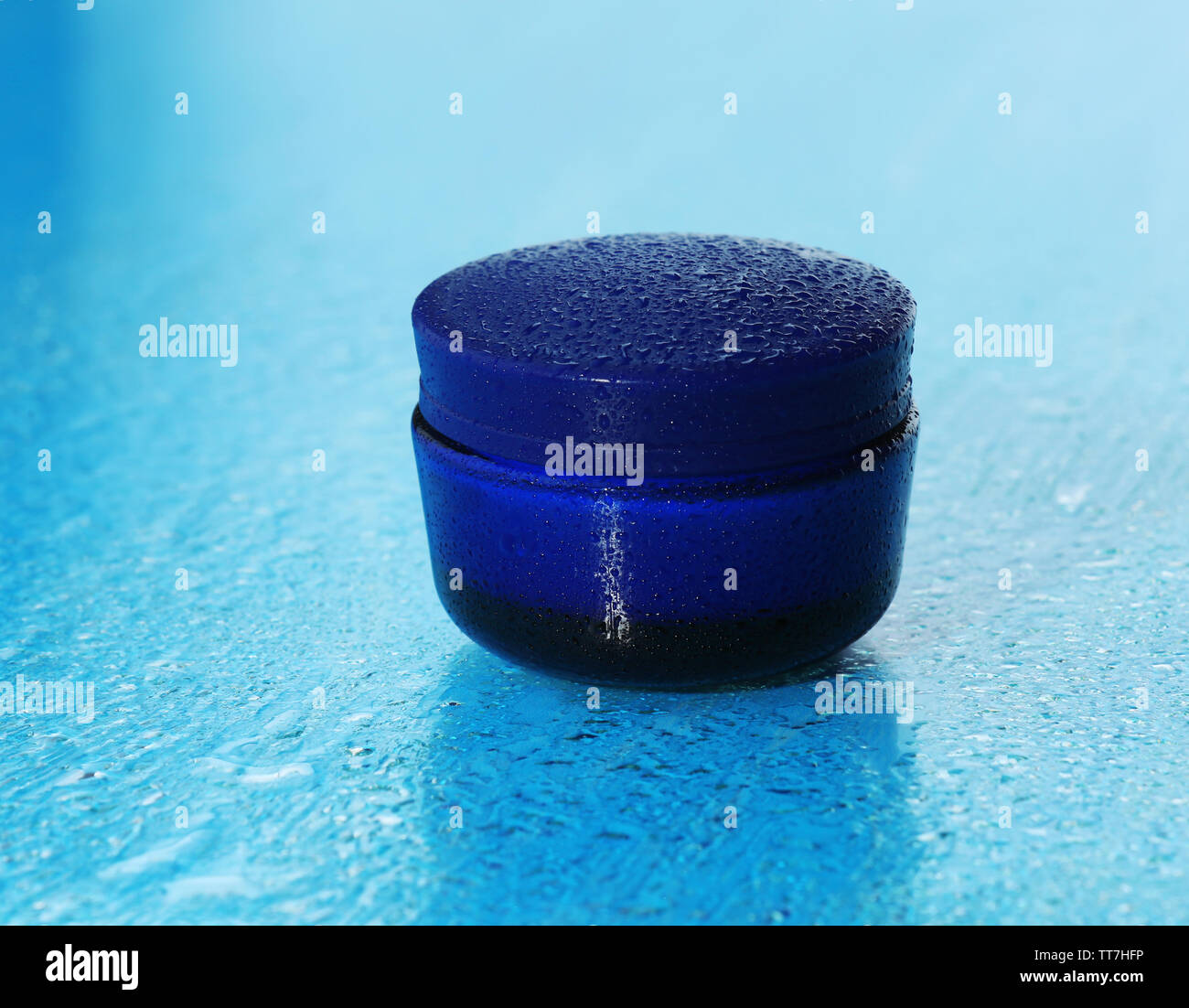 Cosmetic cream on blue background with water drops Stock Photo - Alamy