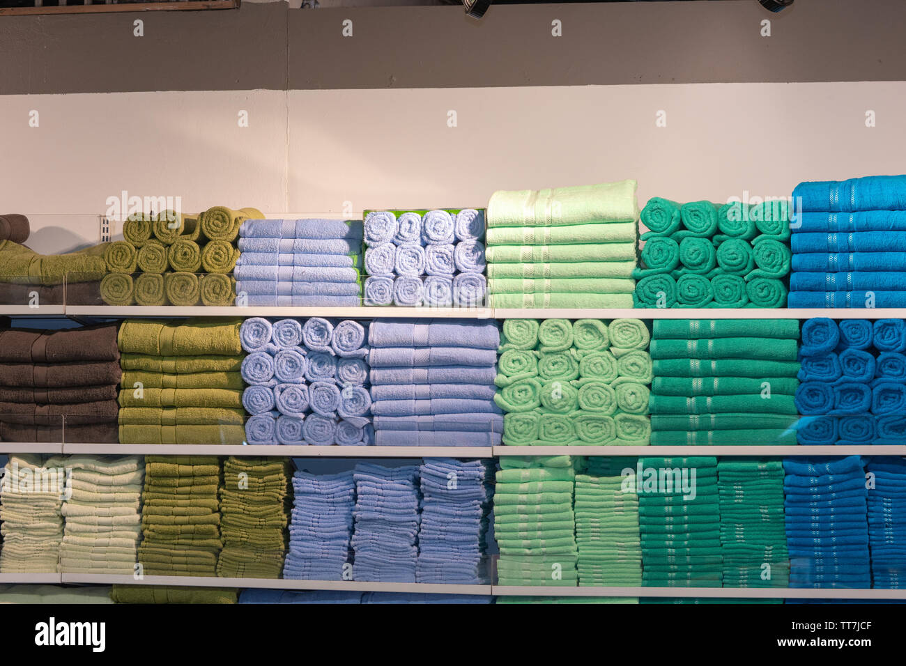 Stack of the multicolored towels on shelf Stock Photo - Alamy