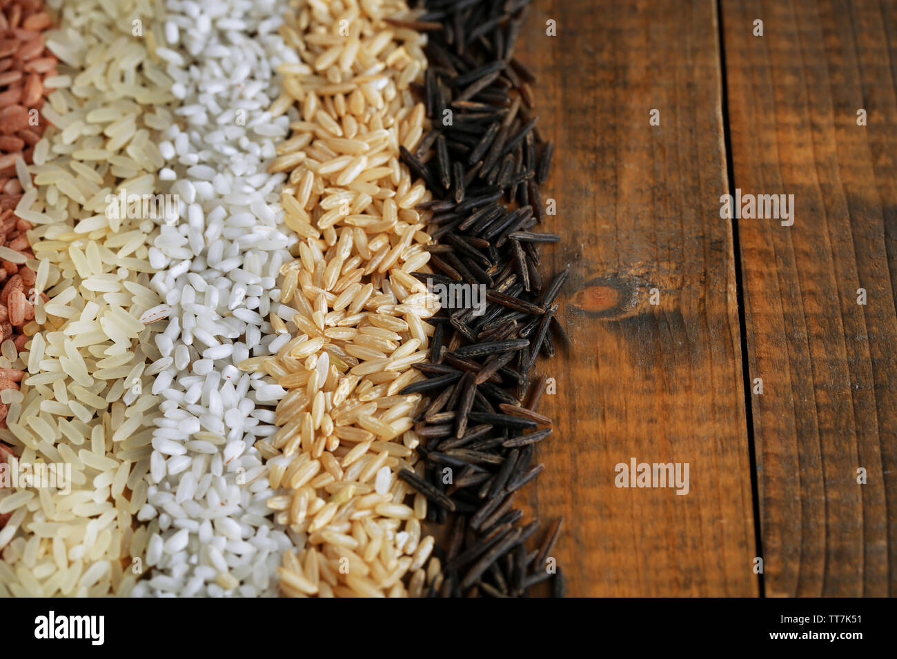Different types of rice on wooden background Stock Photo - Alamy