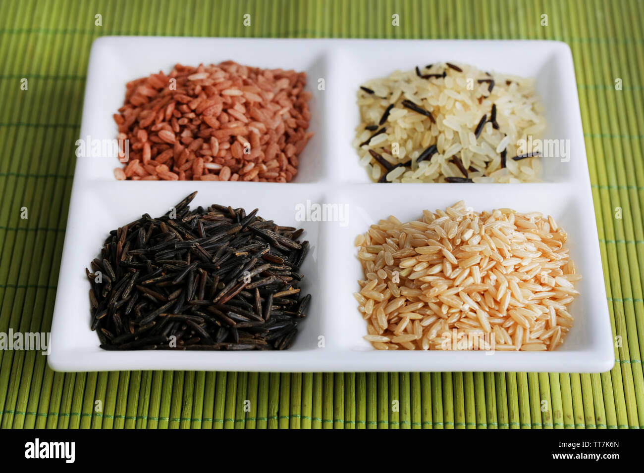 Different types of rice on plate on bamboo background Stock Photo - Alamy