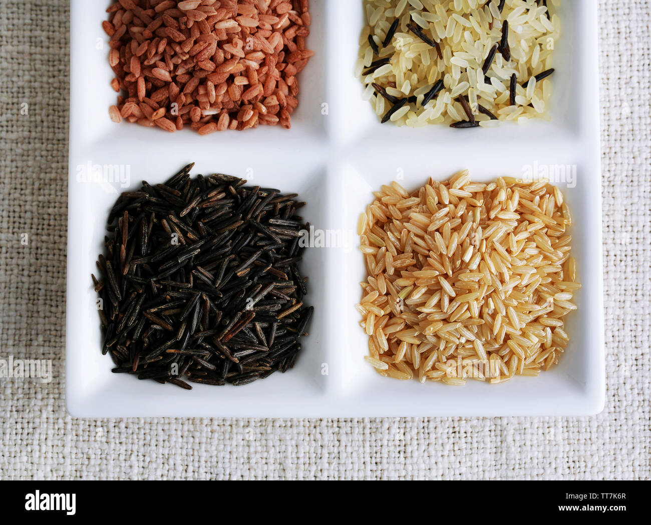 Different types of rice on plate on fabric background Stock Photo - Alamy