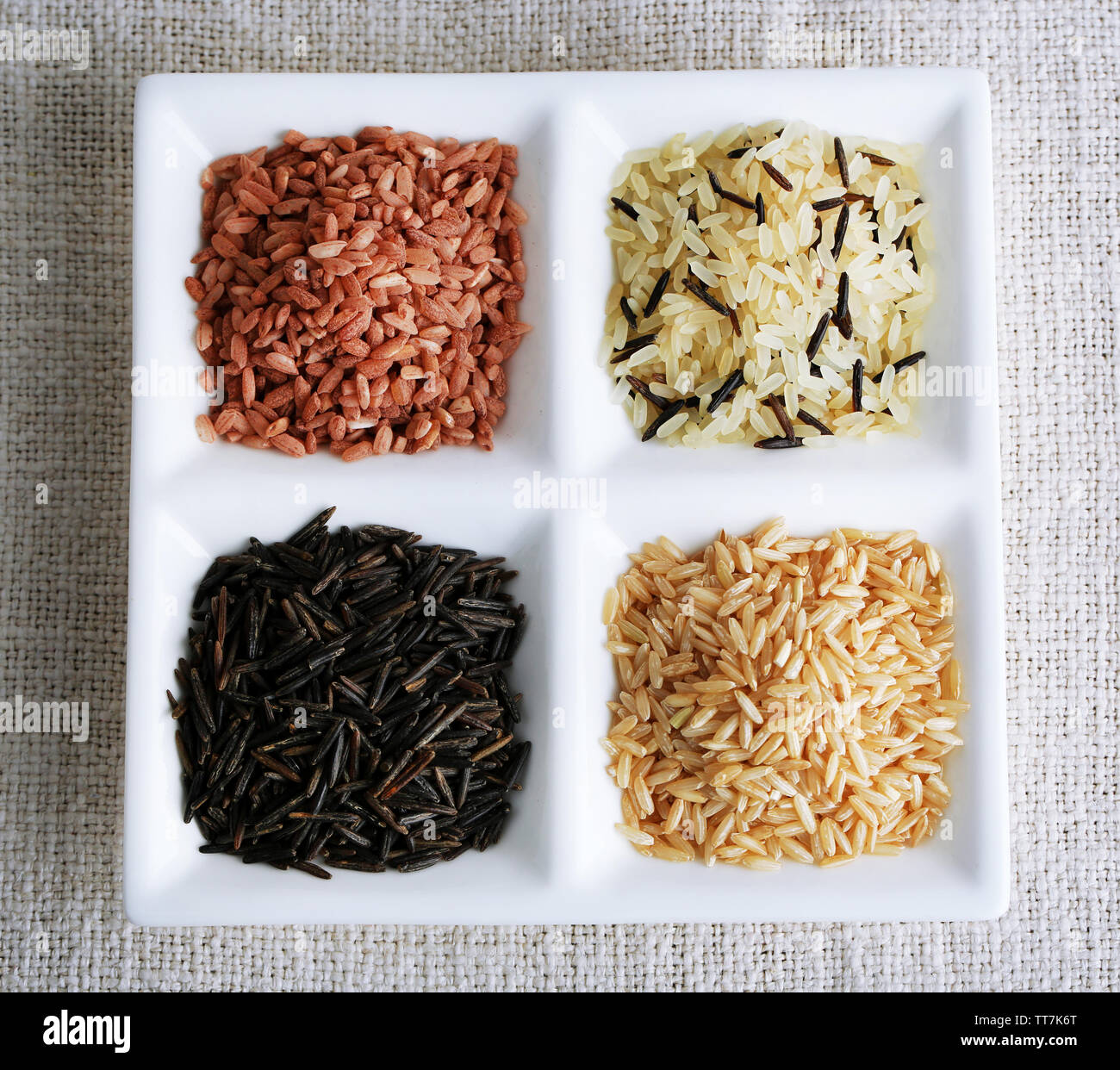Different types of rice on plate on fabric background Stock Photo - Alamy