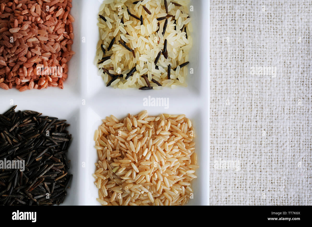 Different types of rice on plate on fabric background Stock Photo - Alamy