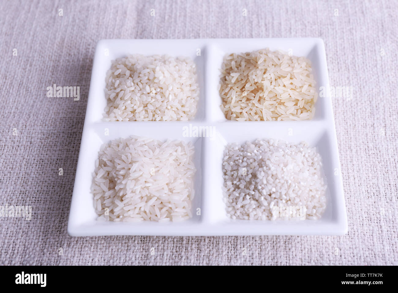 Different types of rice on plate on fabric background Stock Photo - Alamy
