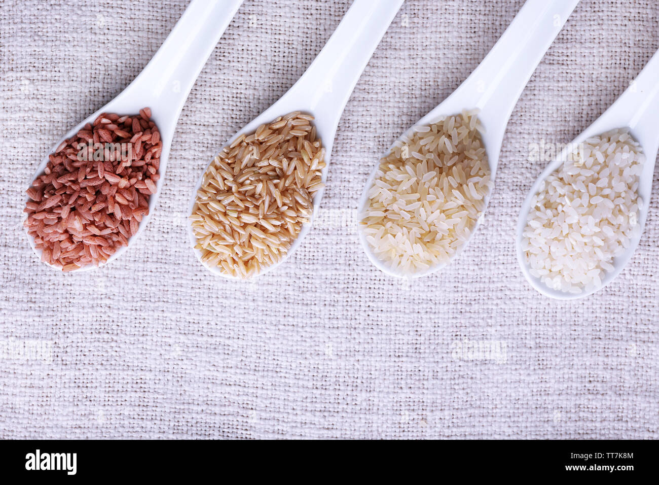 Different types of rice in spoons on fabric background Stock Photo - Alamy