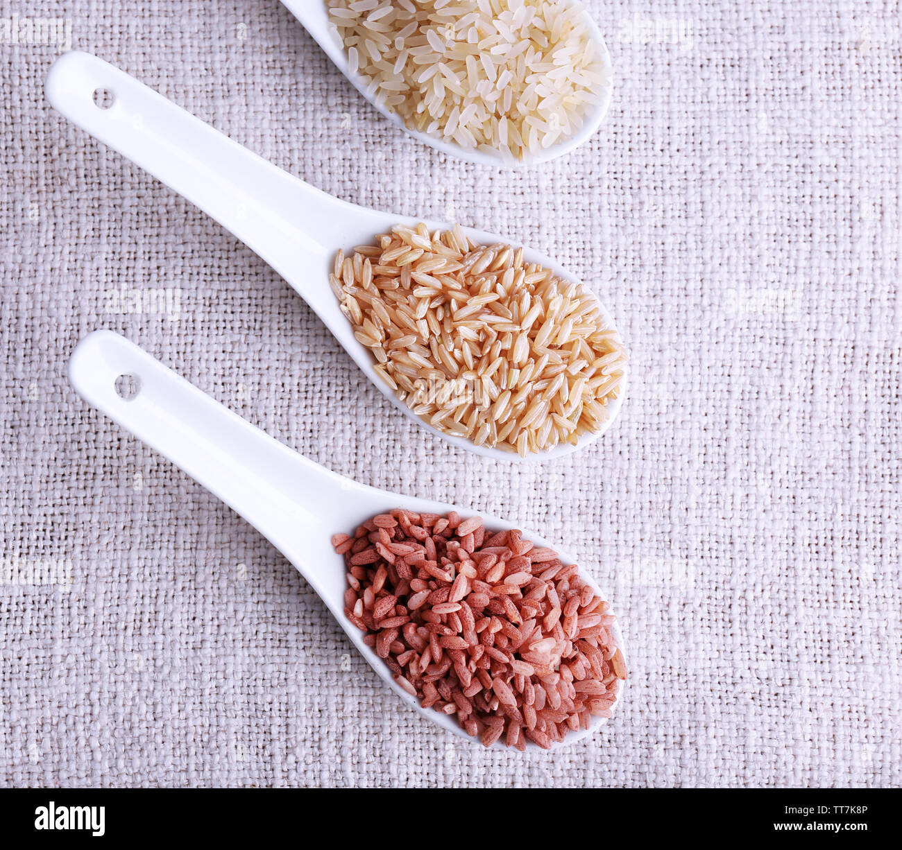 Different types of rice in spoons on fabric background Stock Photo - Alamy