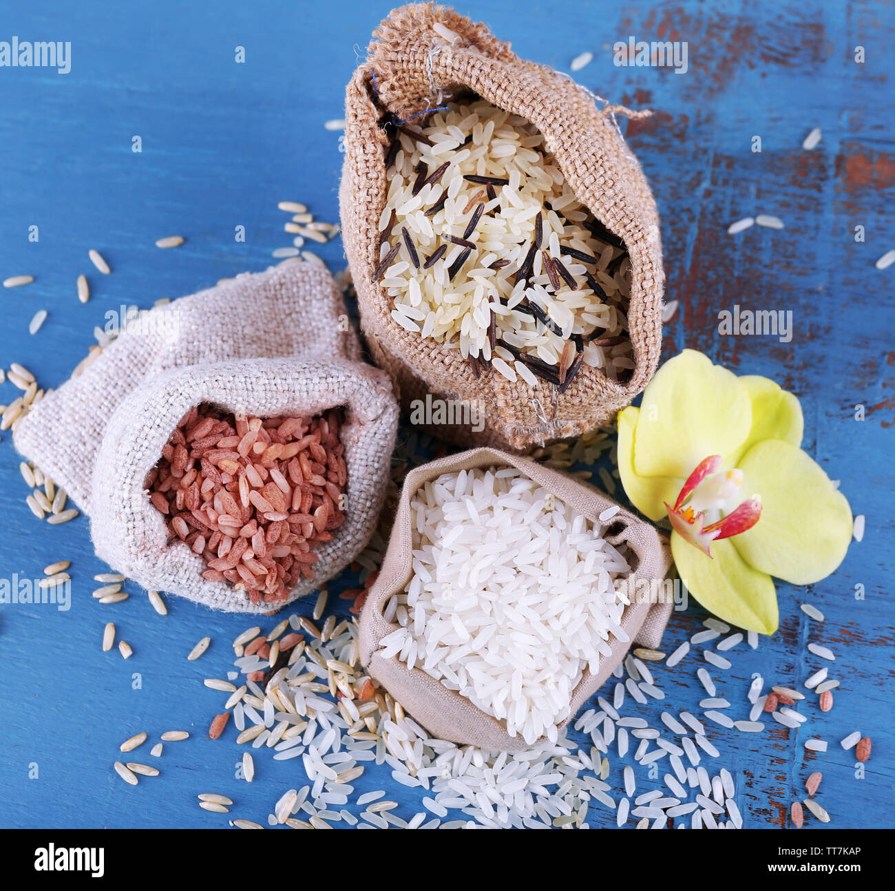 Different types of rice in sacks on wooden background Stock Photo - Alamy