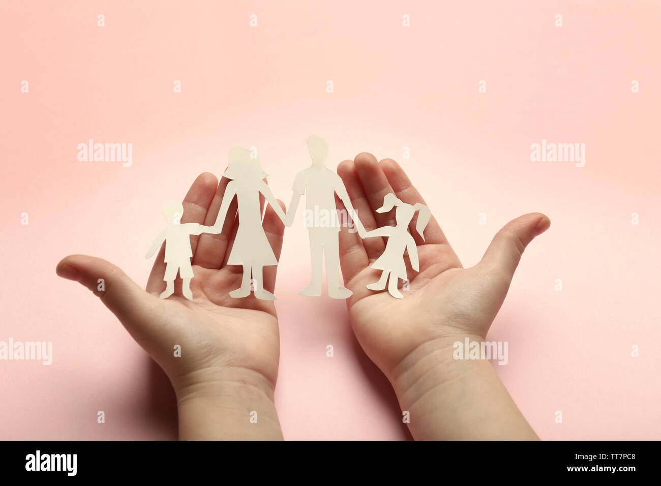 Paper family in child hands on pink background Stock Photo - Alamy