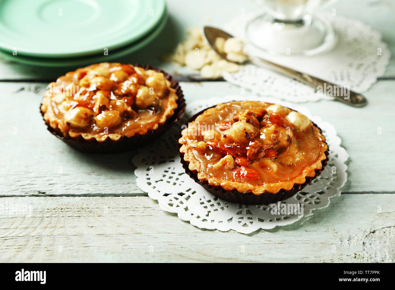 Mini cakes with nuts on lace doily on color wooden background Stock ...