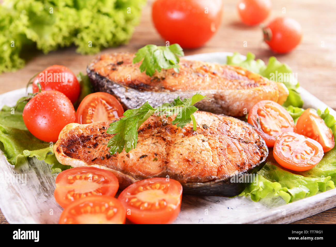 Tasty baked fish on plate on table close-up Stock Photo - Alamy