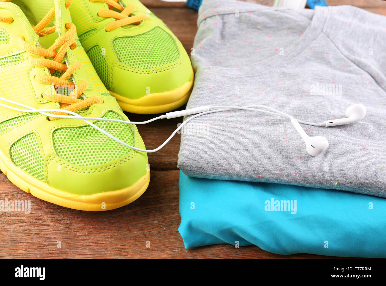 Sport shoes and clothes on wooden background Stock Photo - Alamy