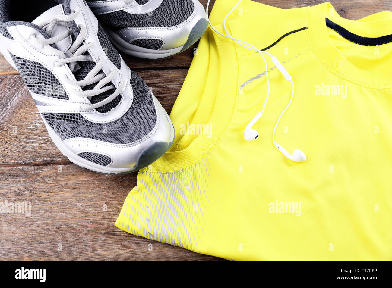Sport shoes and clothes on wooden background Stock Photo - Alamy