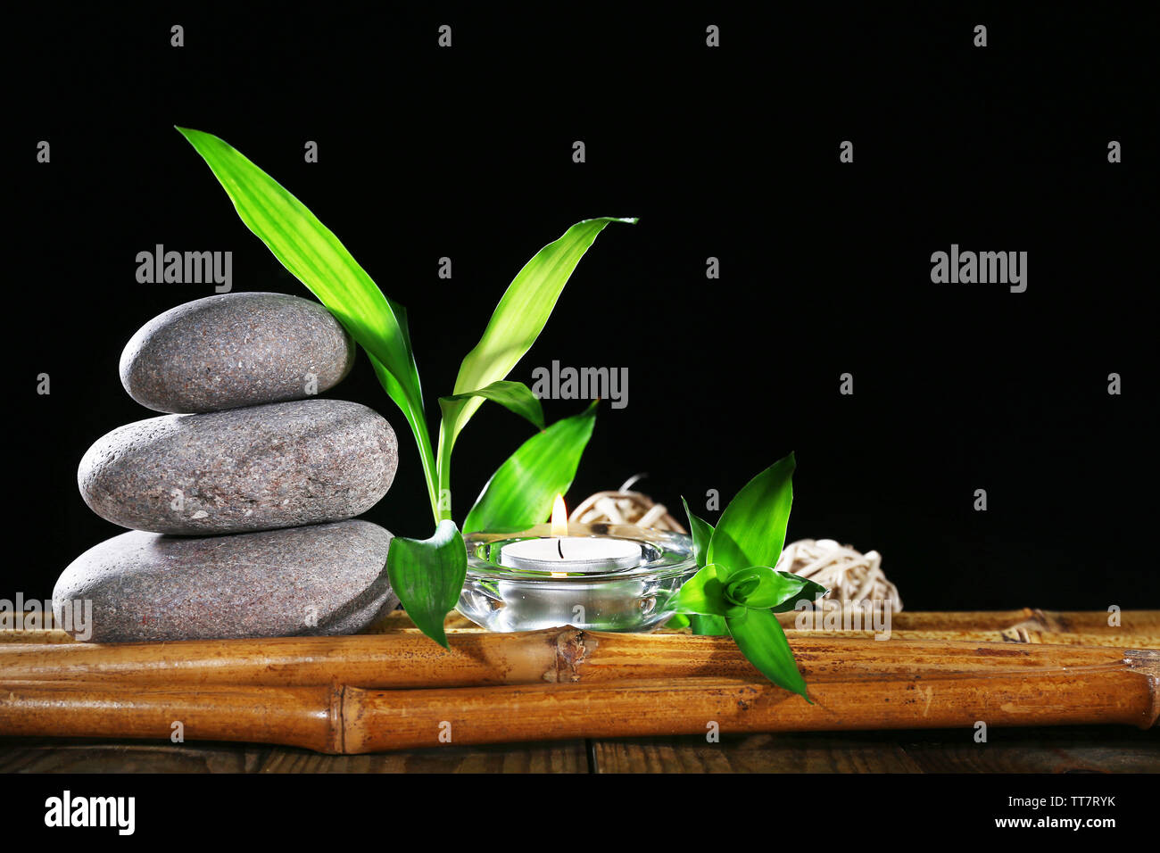 Beautiful composition with spa stones and candle on table on dark ...