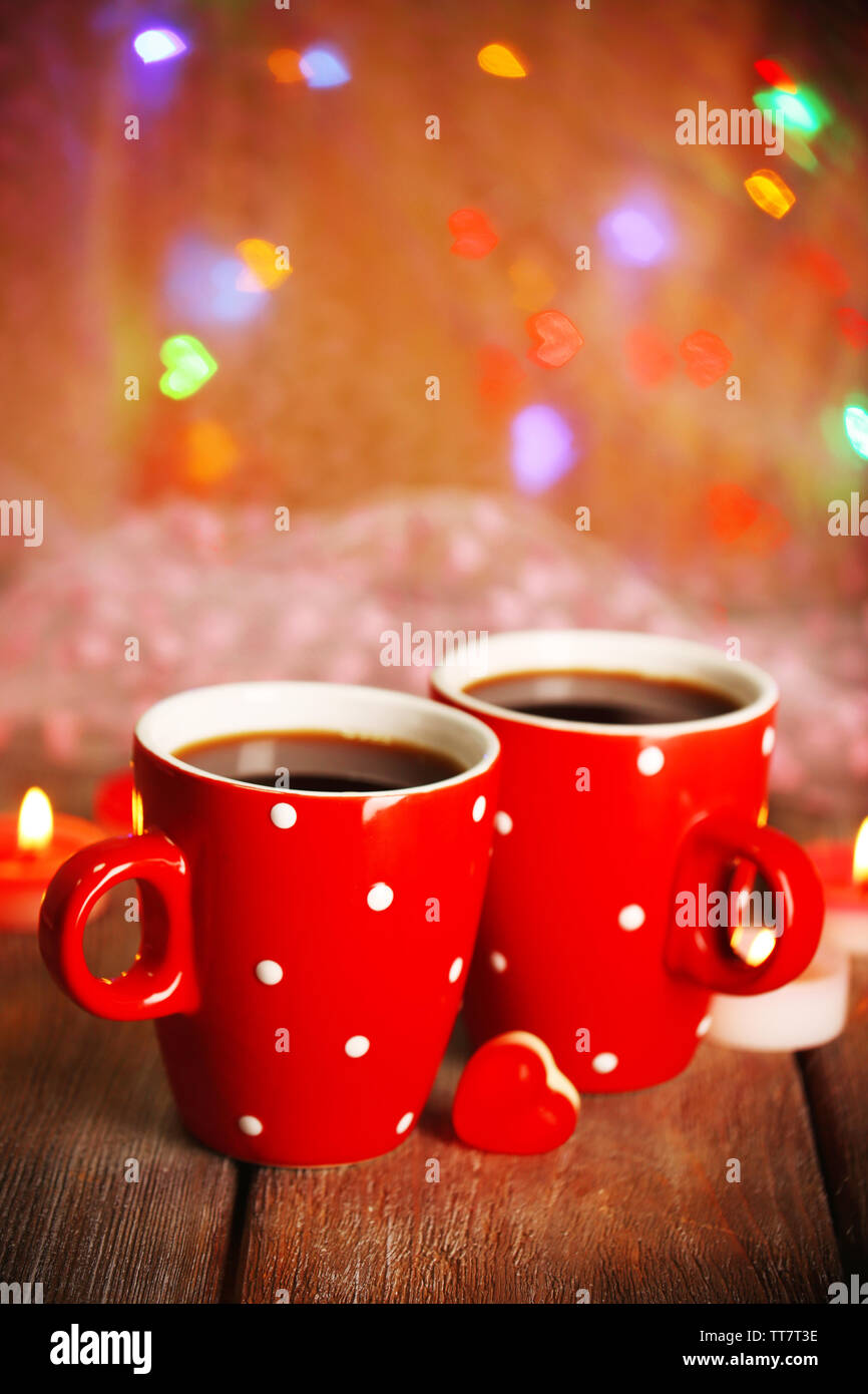 Two red cups on table on lights background Stock Photo - Alamy