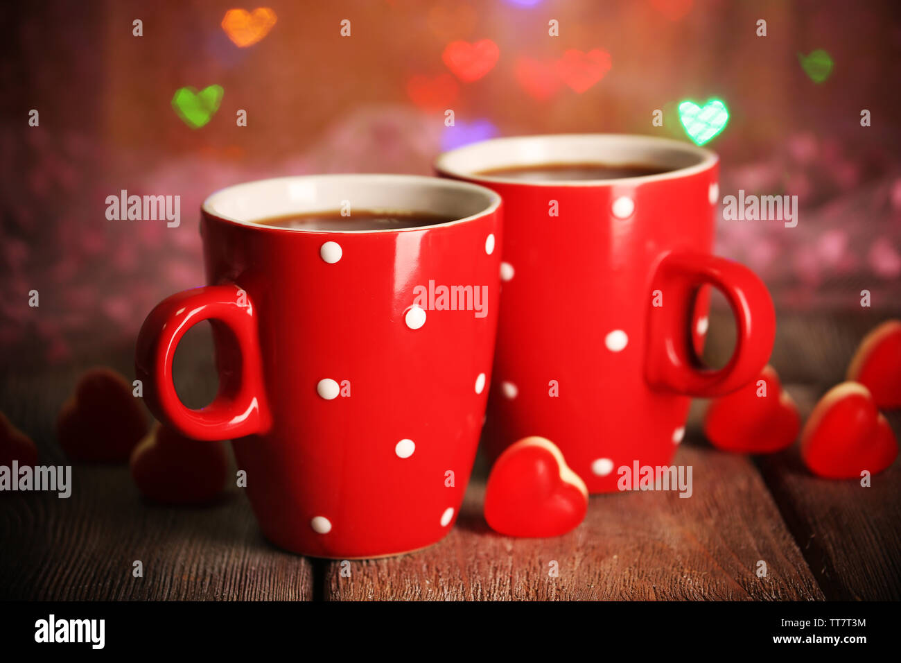 Two red cups on table on lights background Stock Photo - Alamy