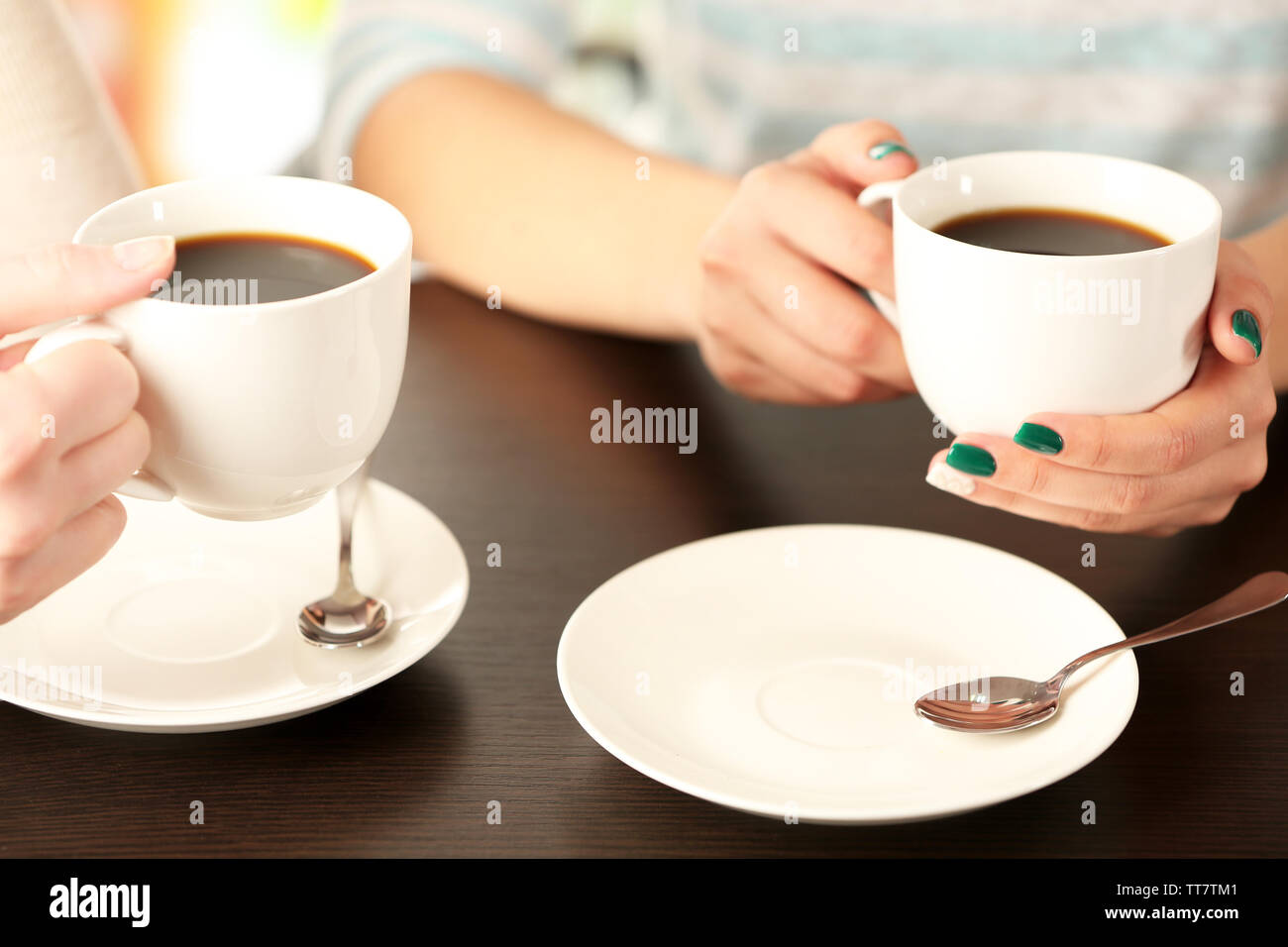 Two women with cups of coffee close up Stock Photo - Alamy