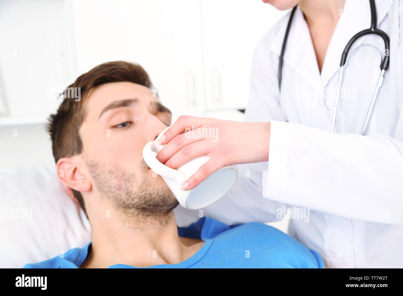 Doctor gives to drink patient close up Stock Photo - Alamy
