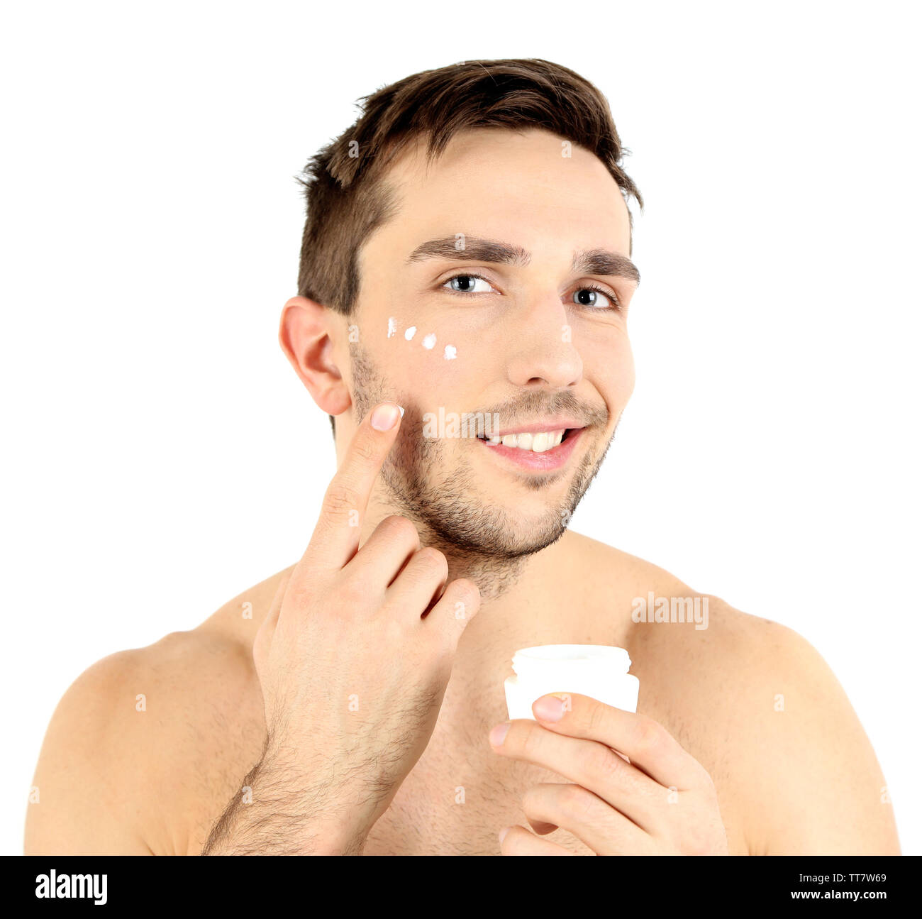 Handsome young man applying cream lotion on face isolated on white Stock Photo - Alamy