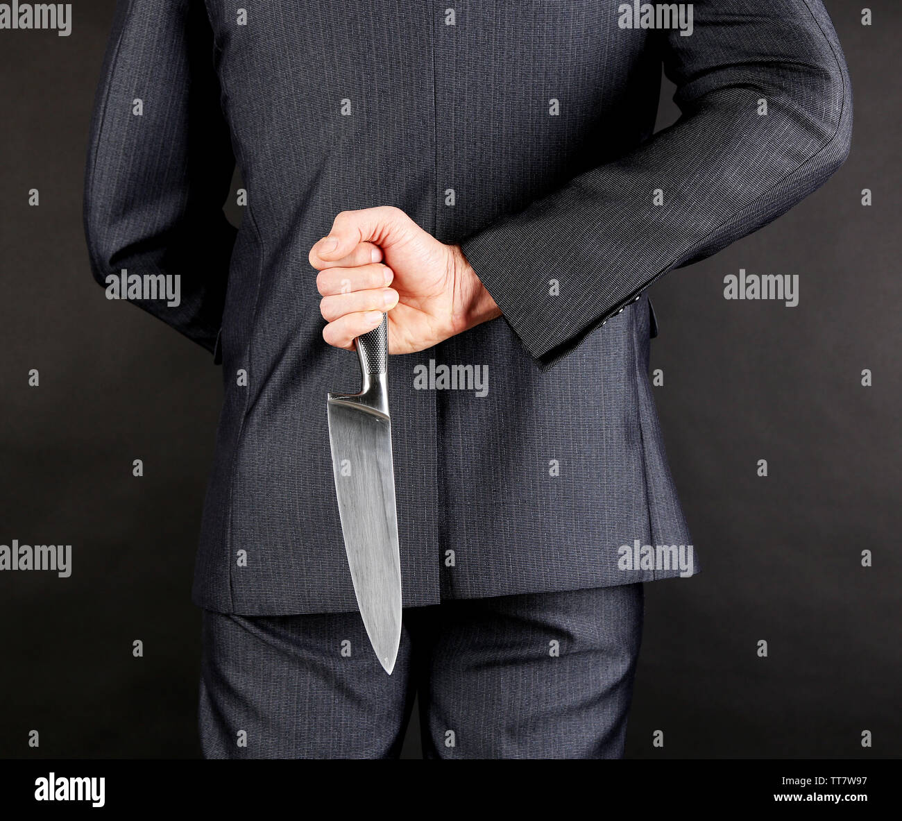 Businessman holding knife behind back hi-res stock photography and ...