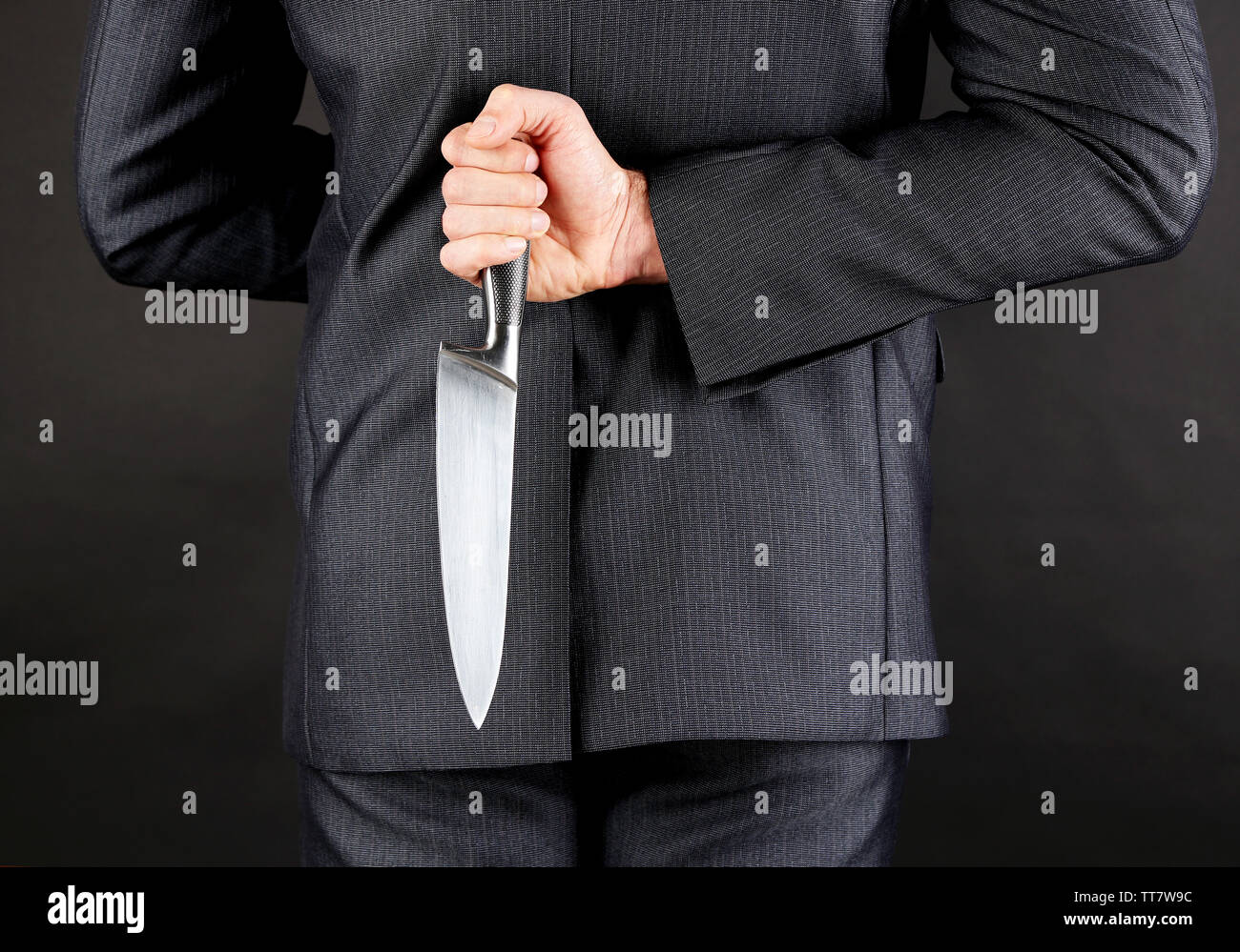 Businessman holding knife behind back hi-res stock photography and ...