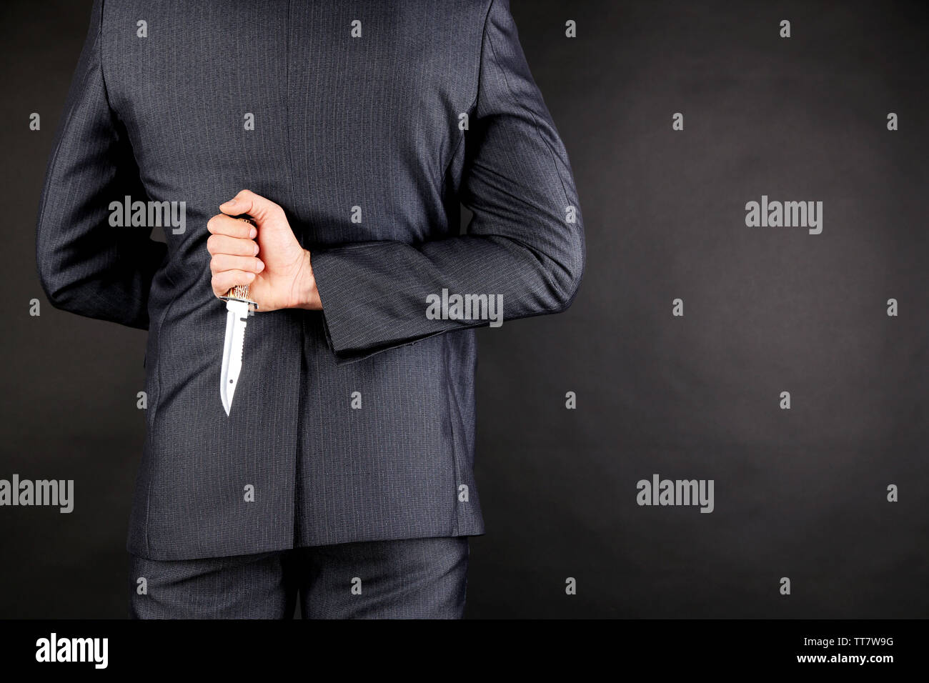 Businessman holding knife behind back hi-res stock photography and ...