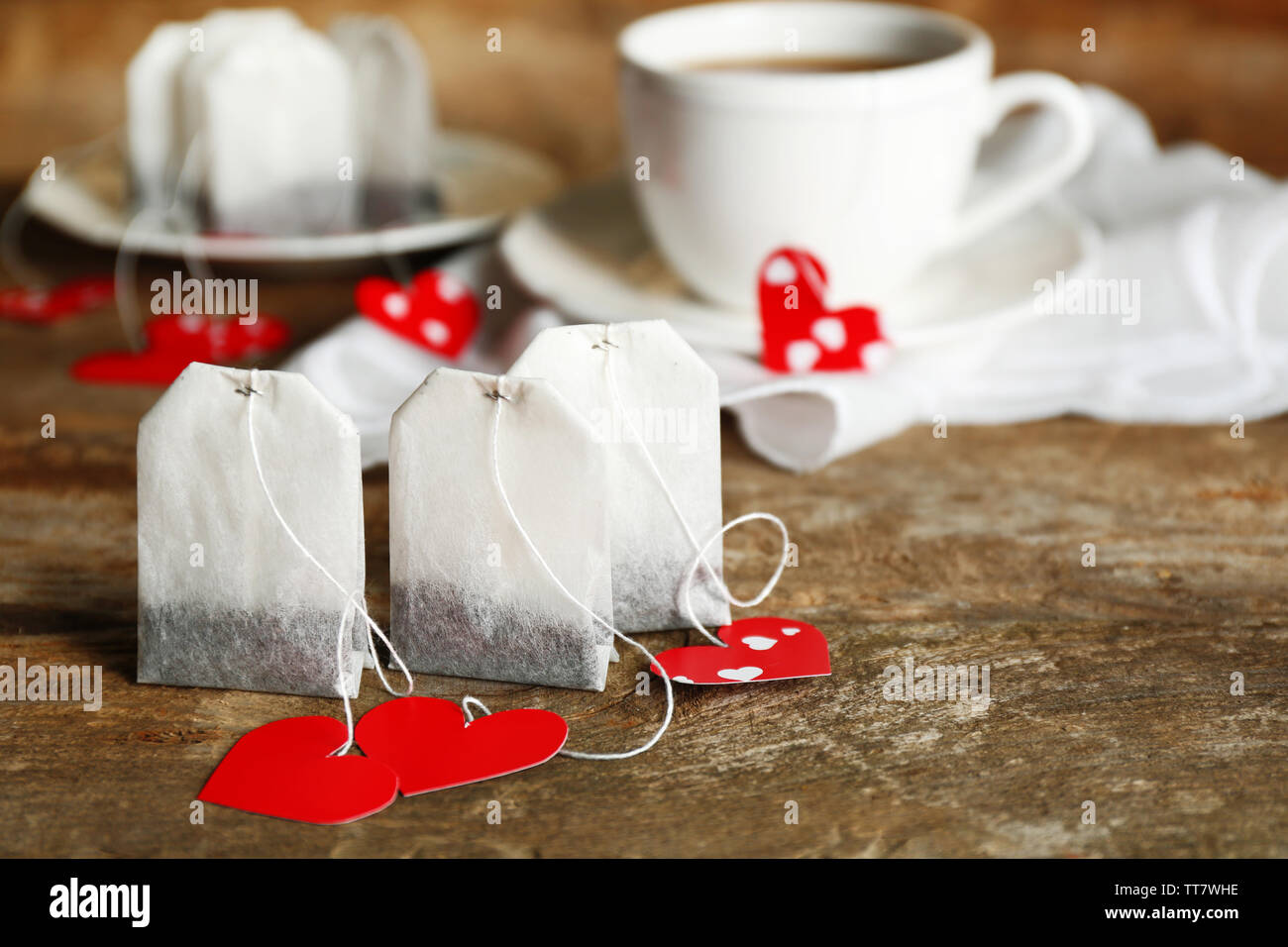 Heart shaped teabag tags and Cup of tea with on wooden background Stock ...