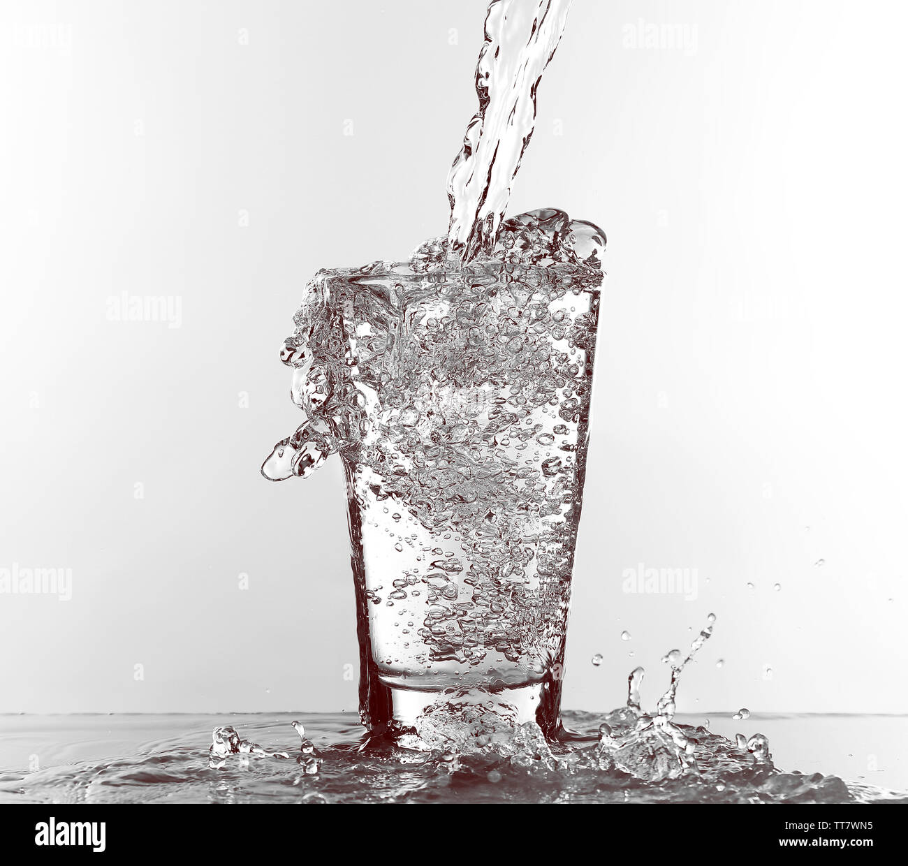 Water pouring in glass isolated on white Stock Photo - Alamy