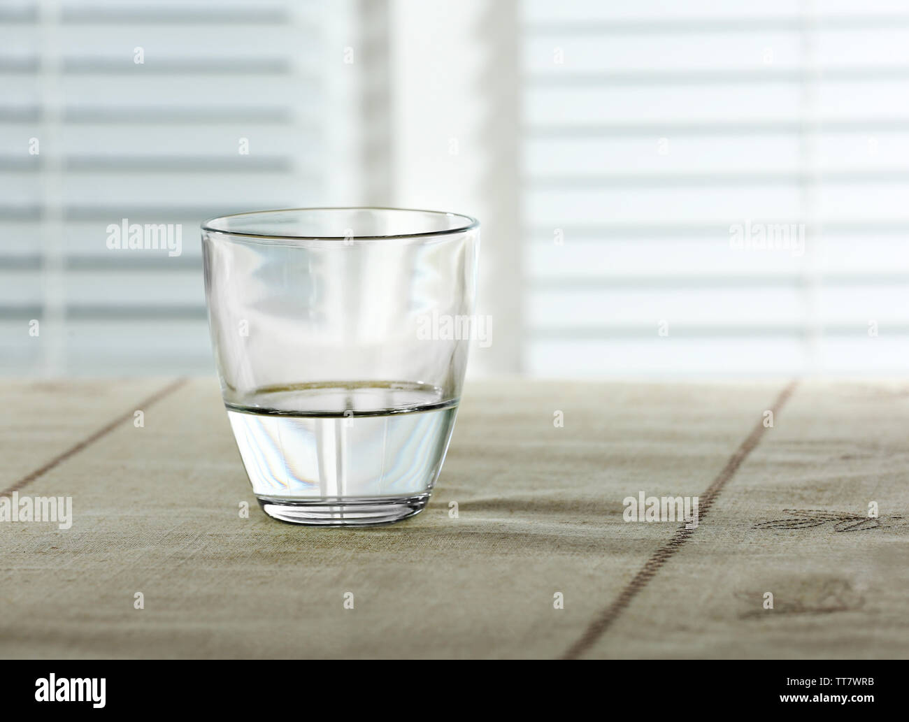 Glass of water on table on light background Stock Photo - Alamy