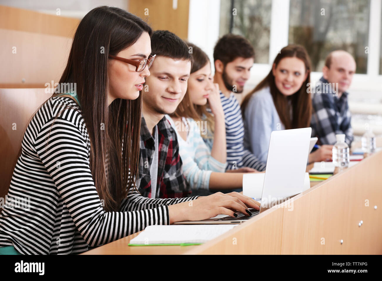 Group of students using gadgets in classroom Stock Photo - Alamy