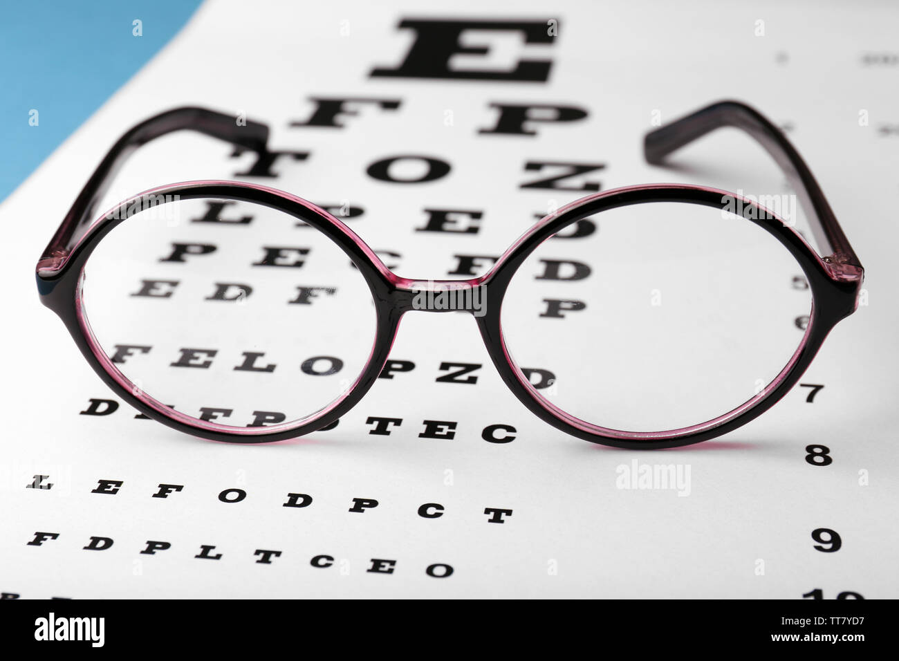 Glasses on eye chart background, close-up Stock Photo - Alamy