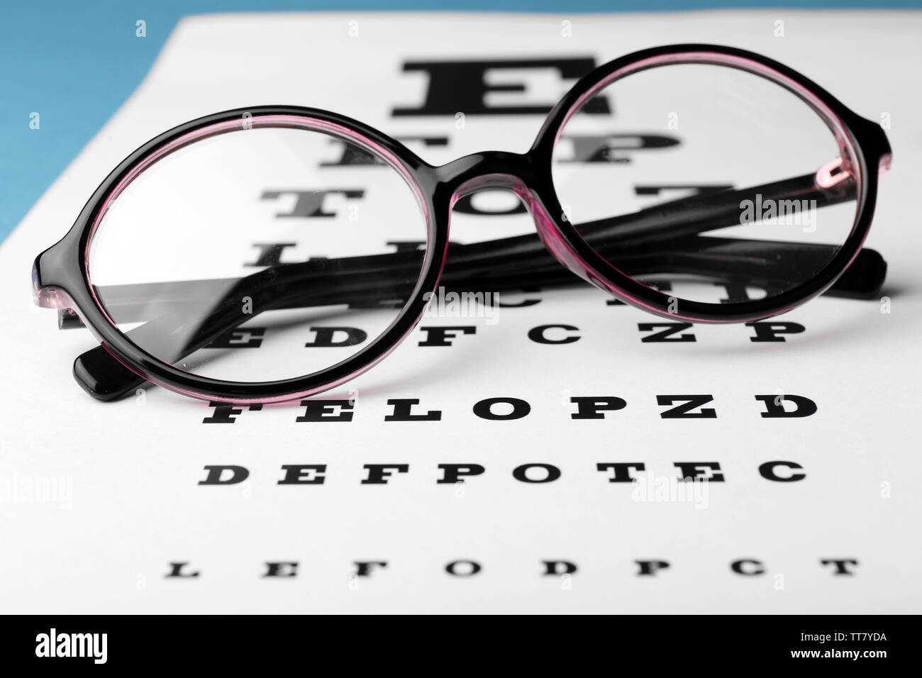 Glasses on eye chart background, close-up Stock Photo - Alamy