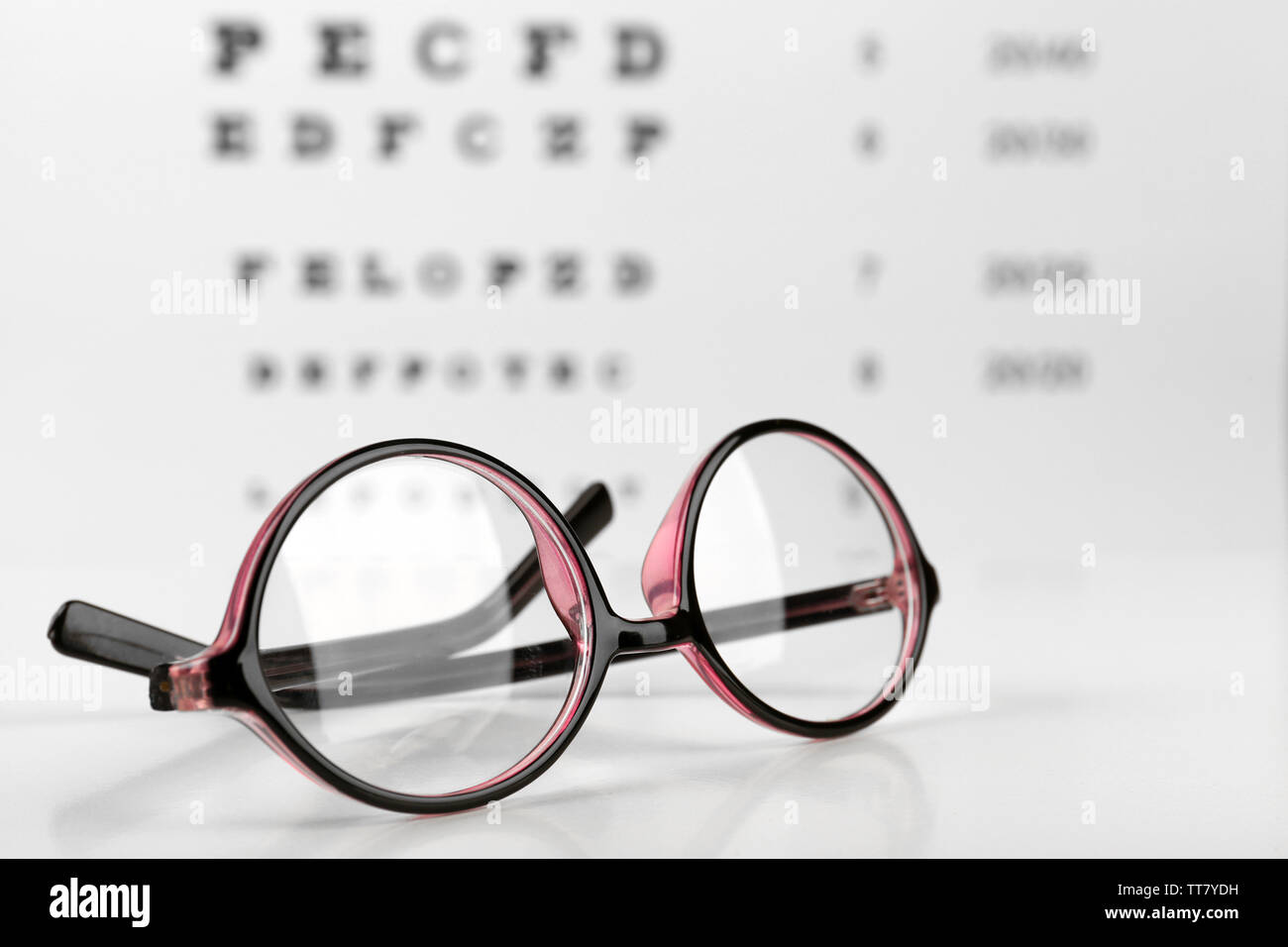 Glasses on eye chart background, close-up Stock Photo - Alamy