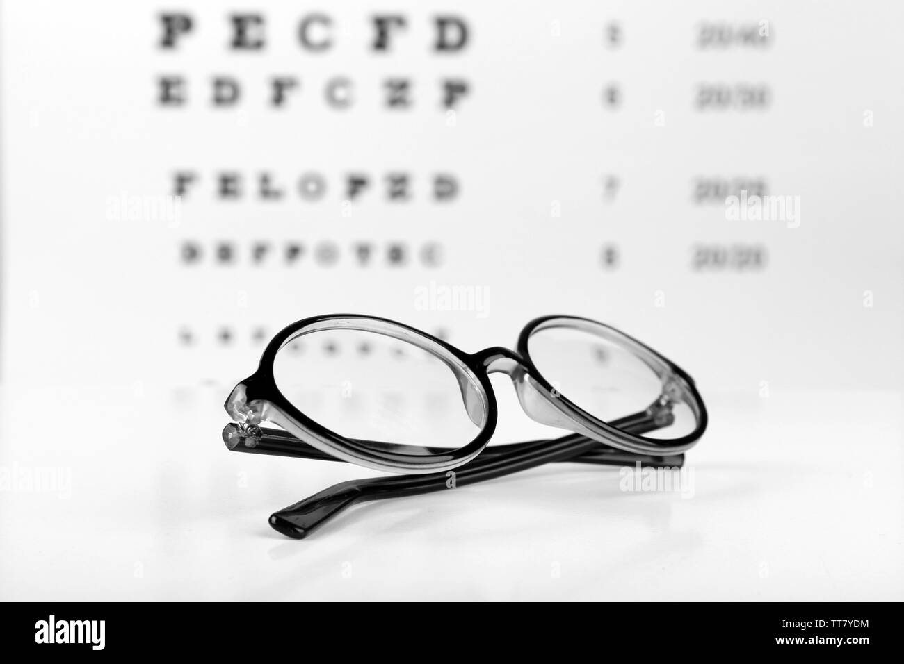 Glasses on eye chart background, close-up Stock Photo - Alamy