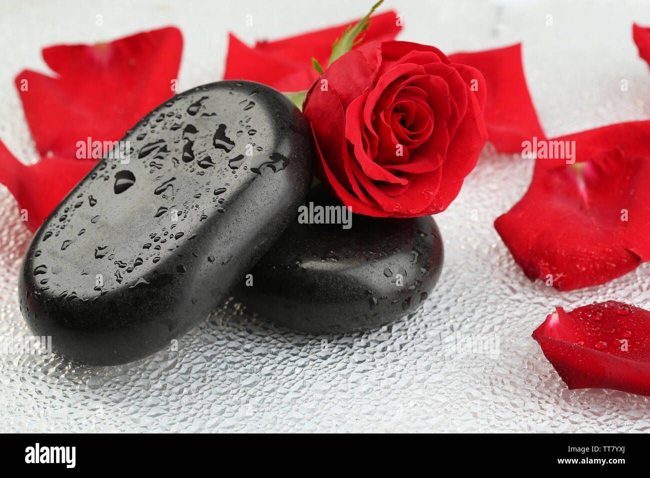 Spa stones and petals on colorful background Stock Photo - Alamy