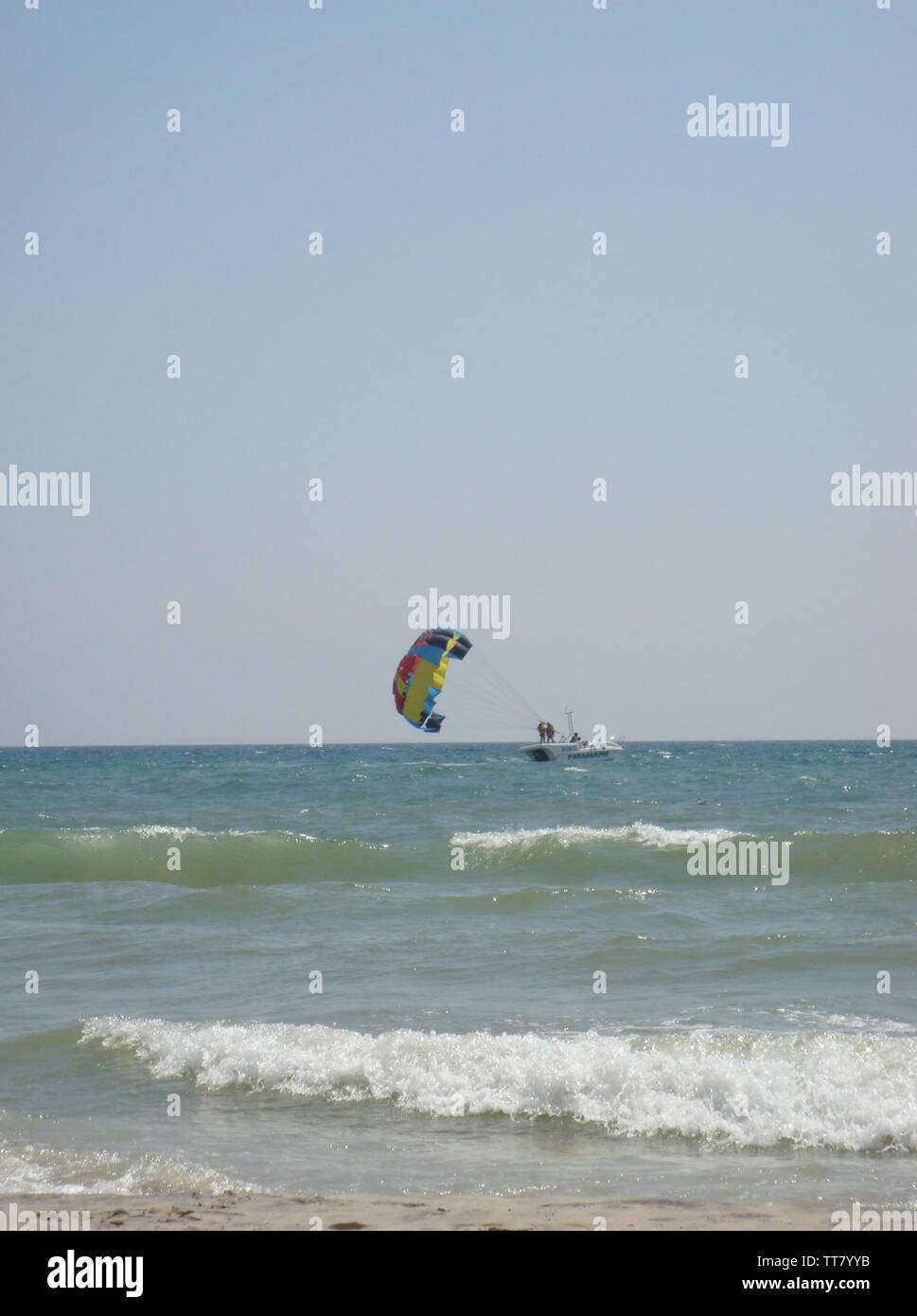 Parasailing over the sea. Flying a tandem paraglider over the sea with ...