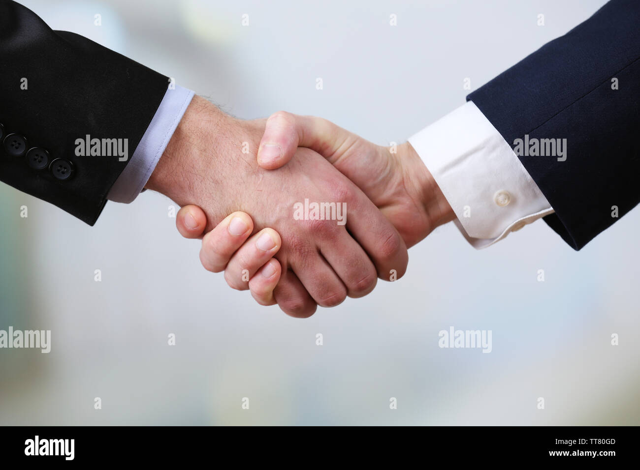 Business handshake on bright background Stock Photo - Alamy