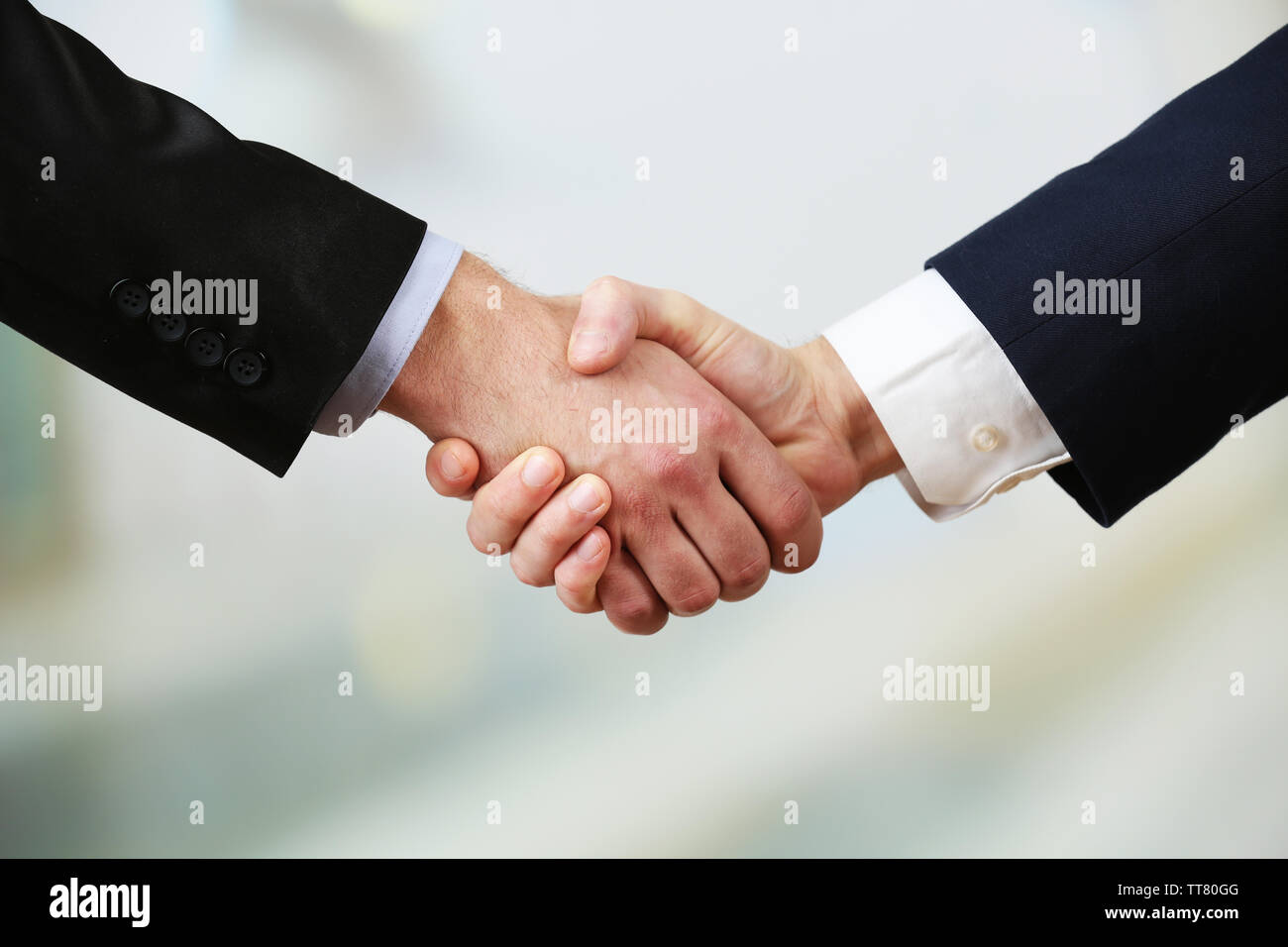 Business handshake on bright background Stock Photo - Alamy
