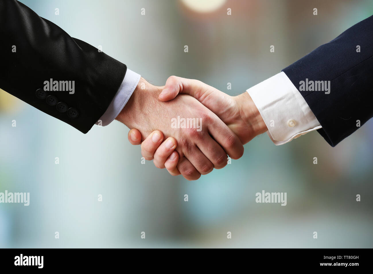 Business handshake on bright background Stock Photo - Alamy