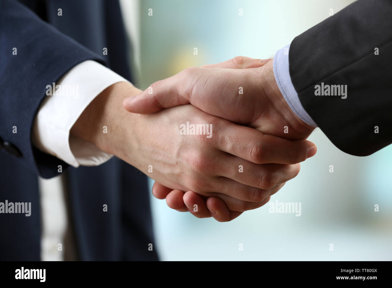 Business handshake on bright background Stock Photo - Alamy